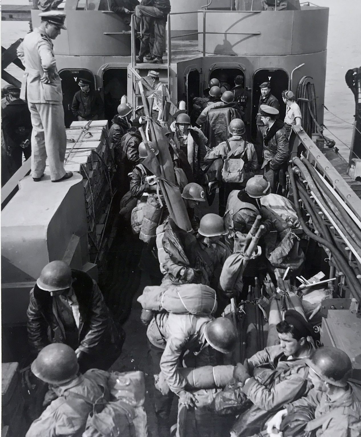 Original Caption: U.S. Navy Beach Battalion boards landing craft at an ...